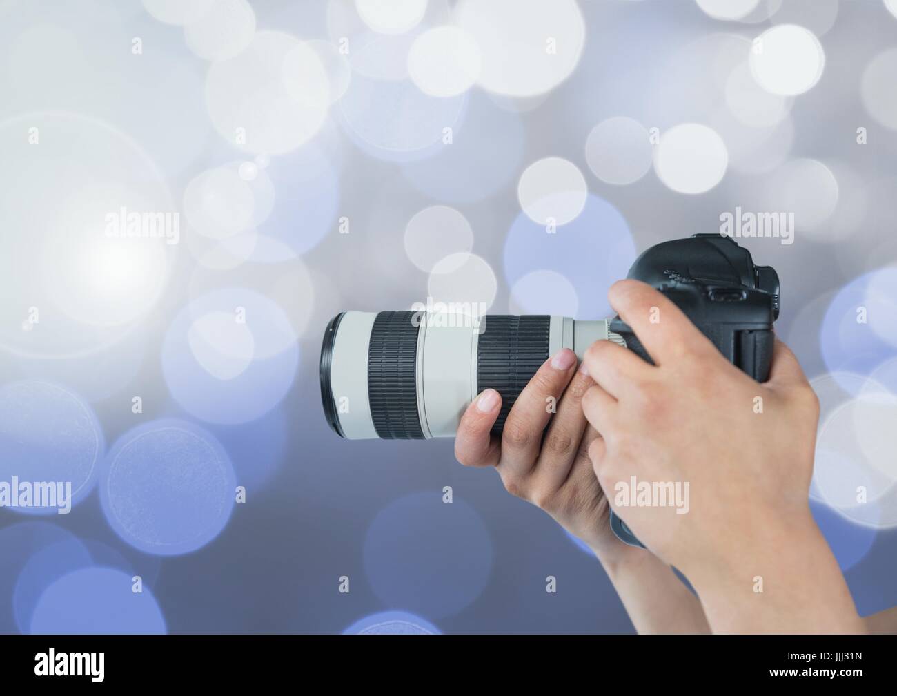 hands holding a camera against glowing background Stock Photo - Alamy