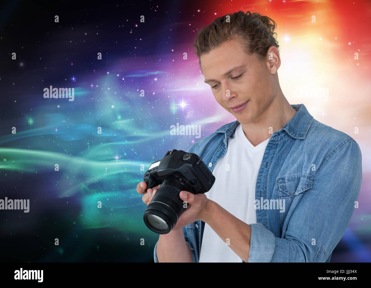 Smiling photographer looking at his camera with lights in colors in ...