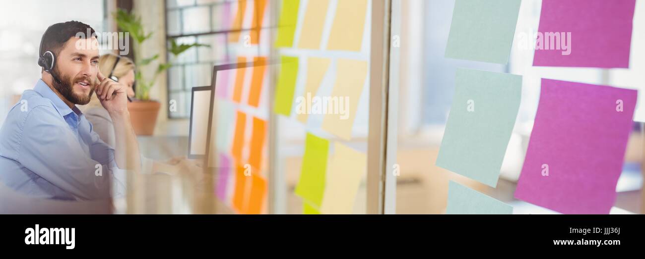 Customer service assistants with headsets with bright sticky notes ...