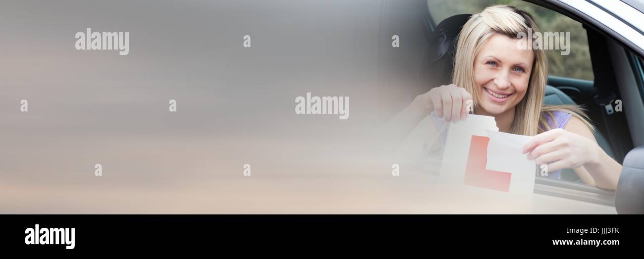 Woman In car with learner L sign ripping with transition and copy space ...