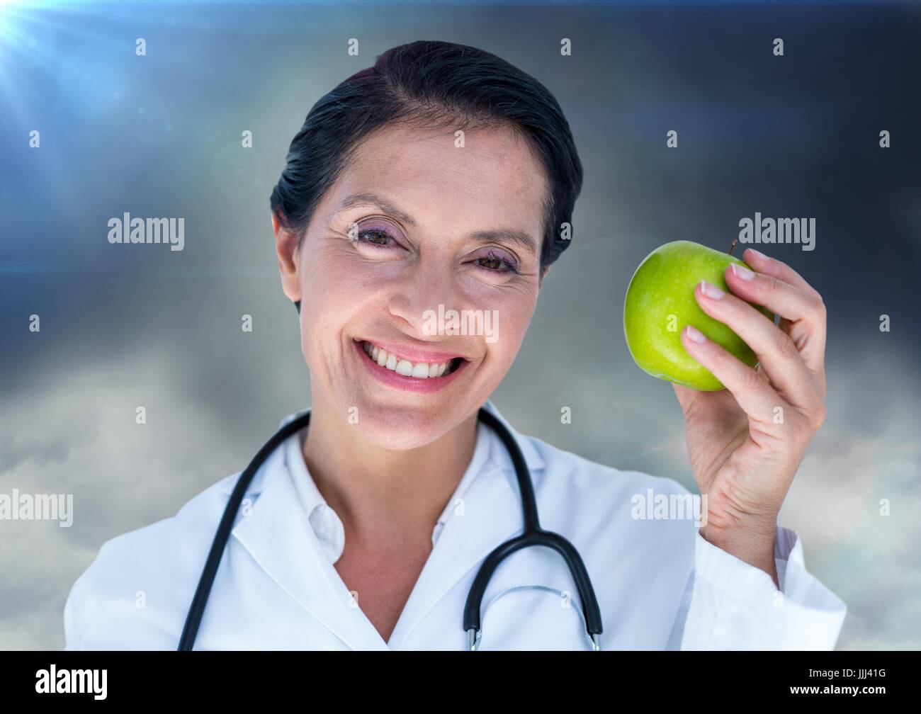 Female doctor with apple against clouds and flares Stock Photo - Alamy