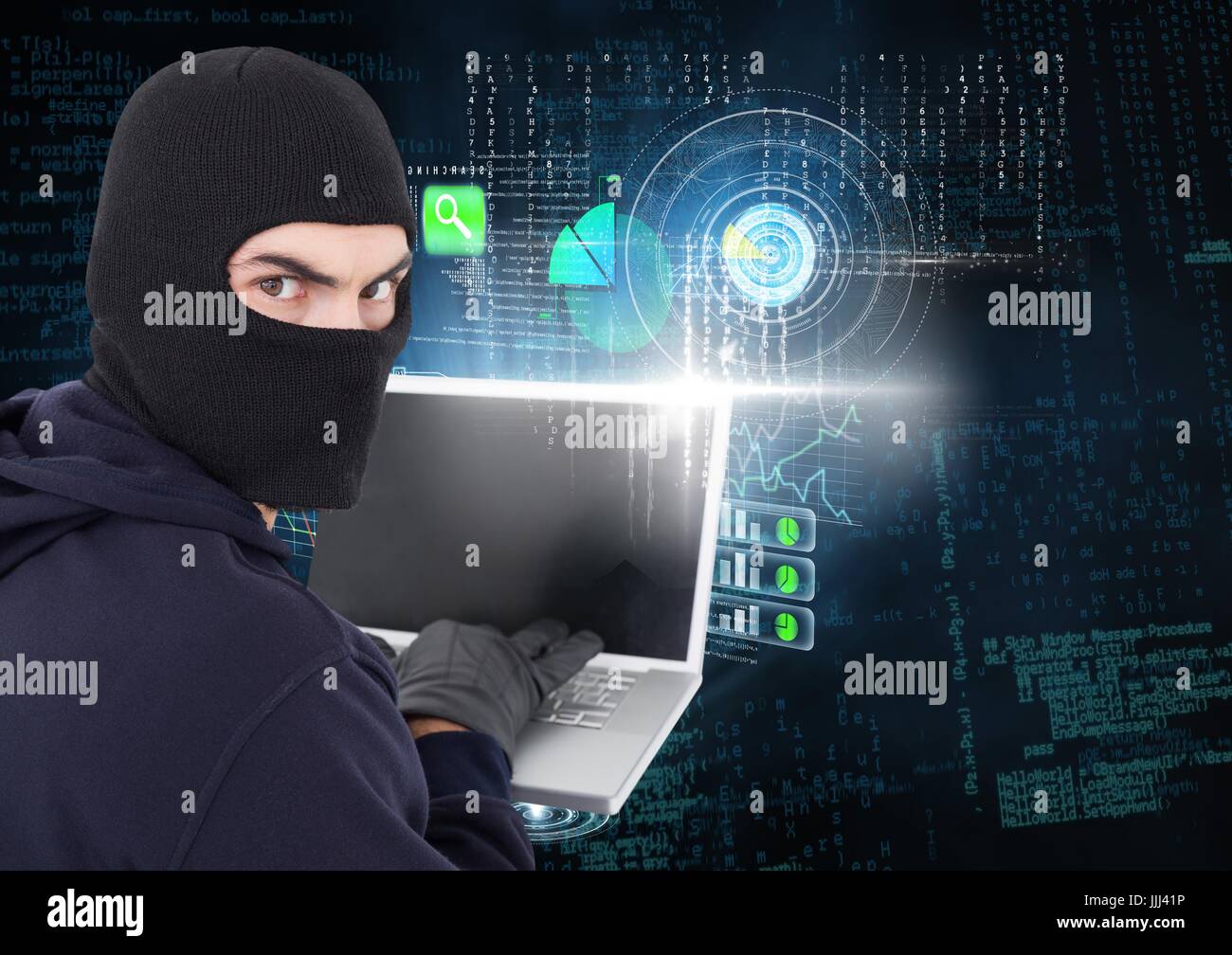 Hacker looking the lens and using a laptop in front of digital ...