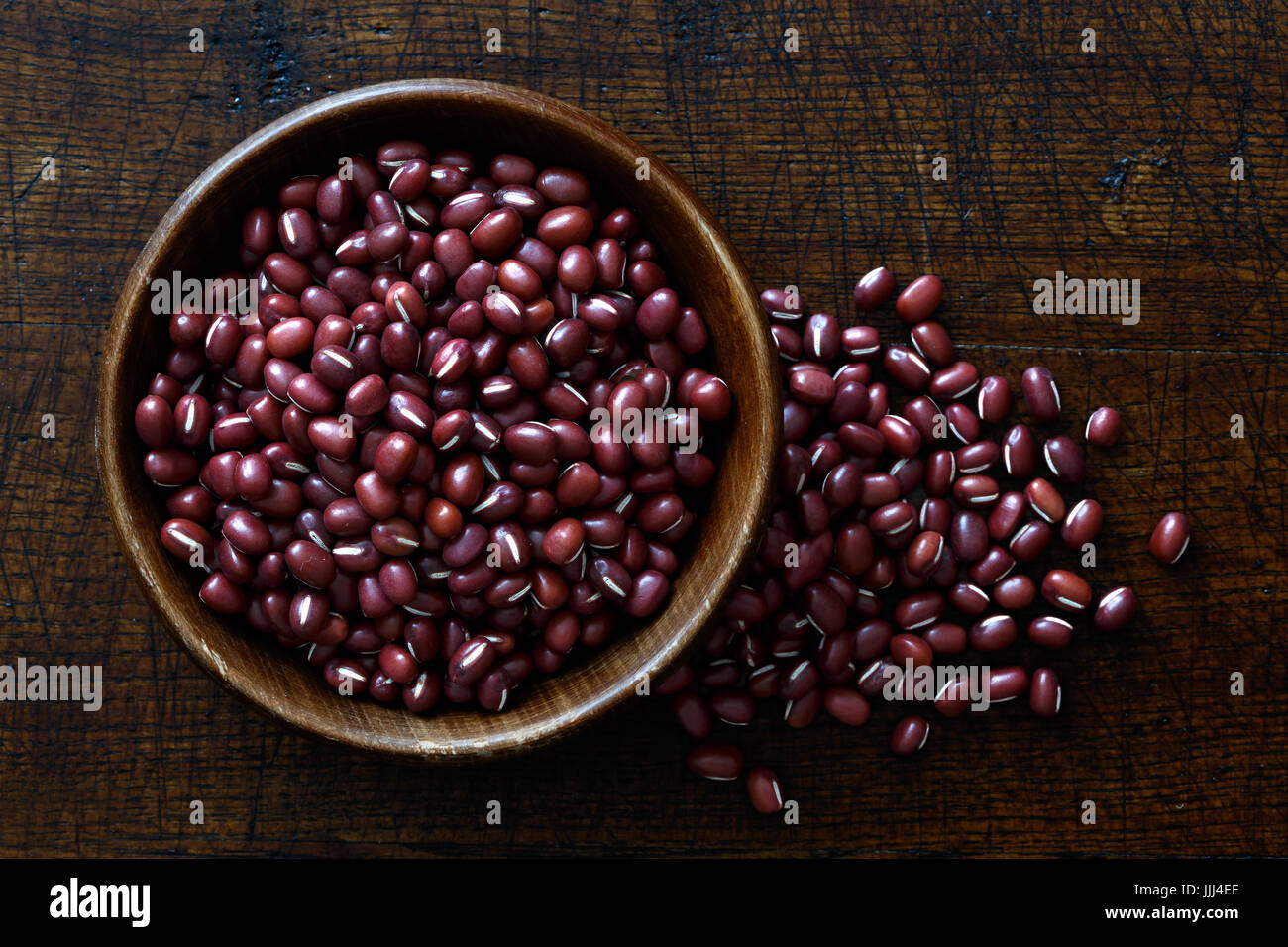 Dry adzuki beans in dark wooden bowl isolated on dark brown wood from ...
