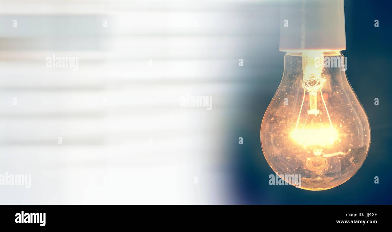 Light bulb with navy background and blurry white and copy space ...