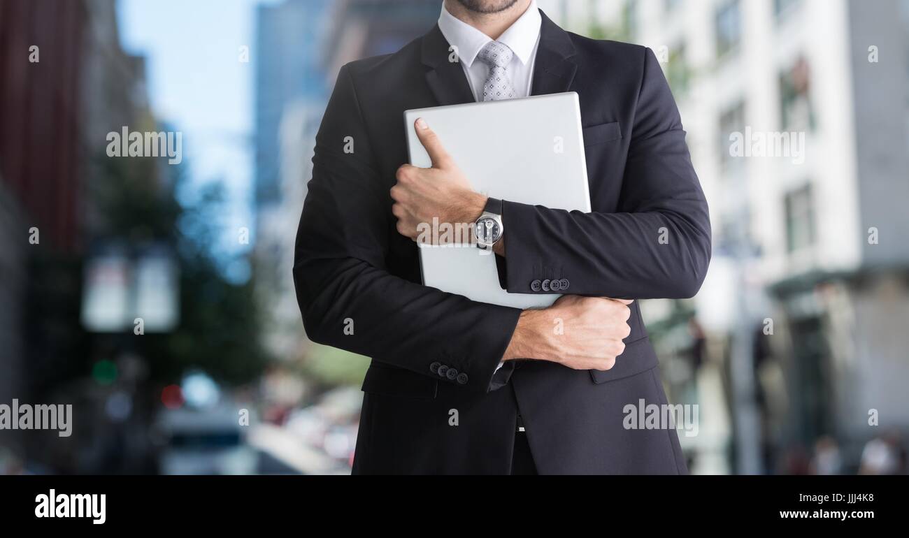 city with businessman holding laptop Stock Photo - Alamy