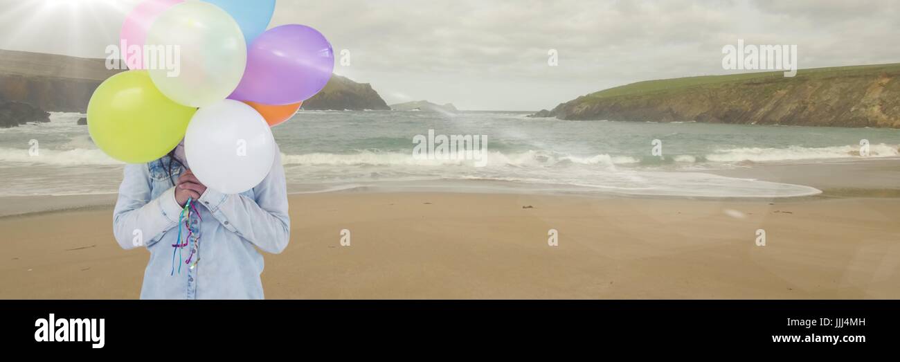 Woman mid section with balloons on beach with flare 3d Stock Photo - Alamy