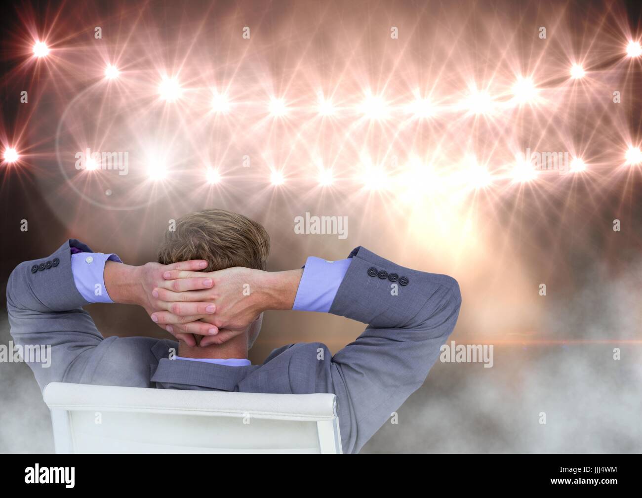 Seated man relaxed with flood lights Stock Photo - Alamy