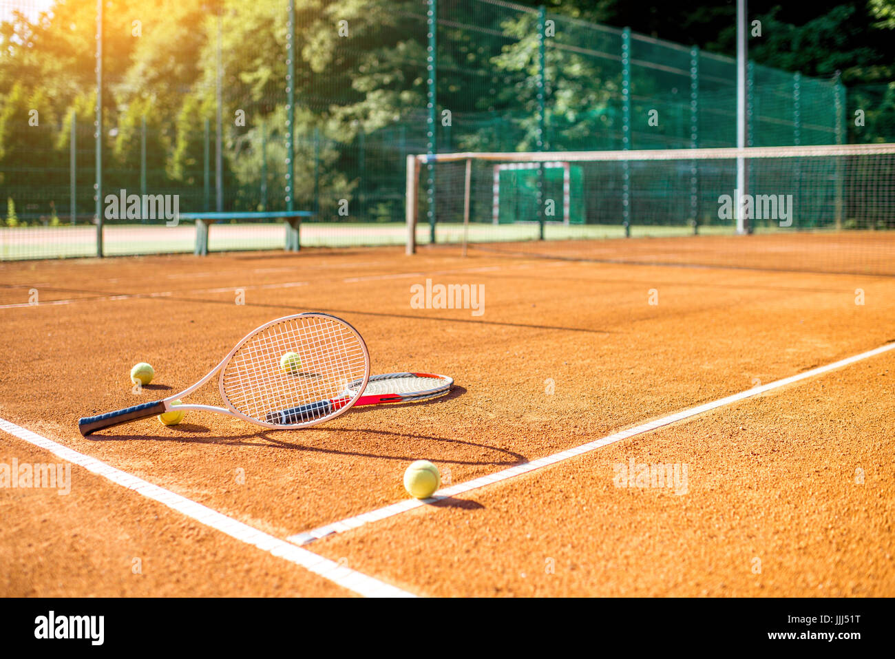 Orange tennis court with rackets and balls outdoors Stock Photo - Alamy