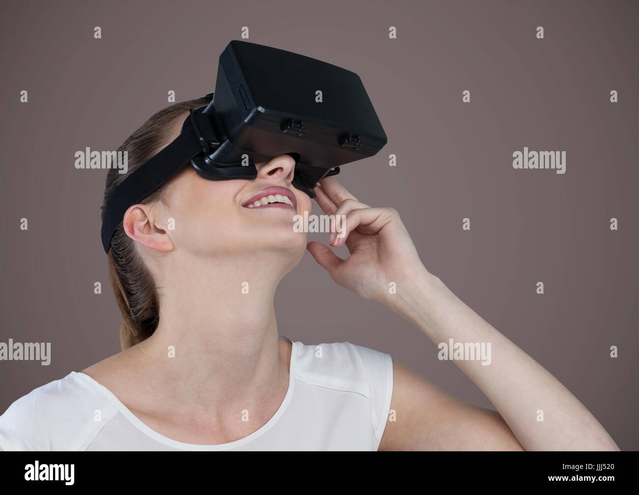Woman in virtual reality headset against brown background Stock Photo ...