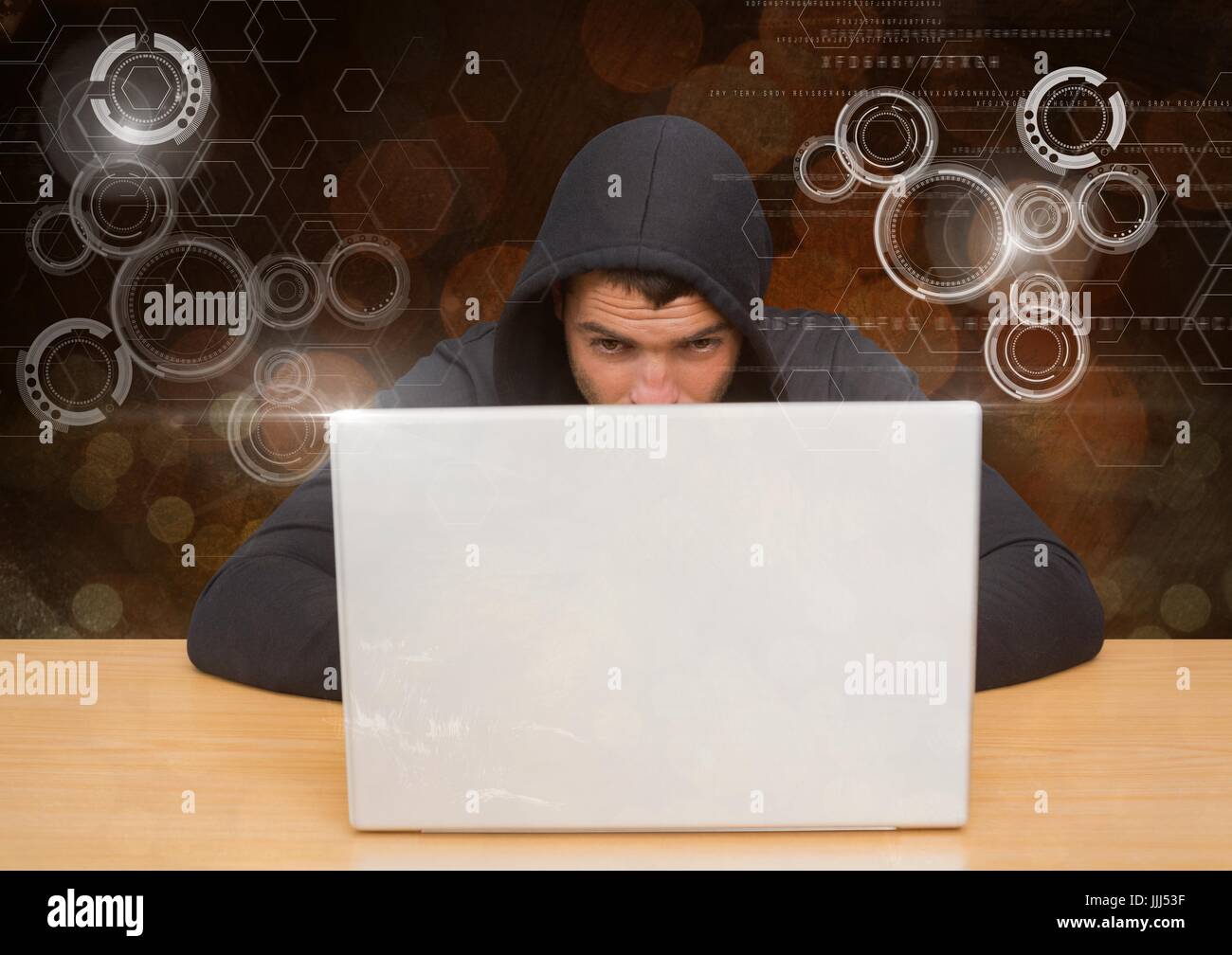 Hacker using a laptop in front of digital orange background Stock Photo ...