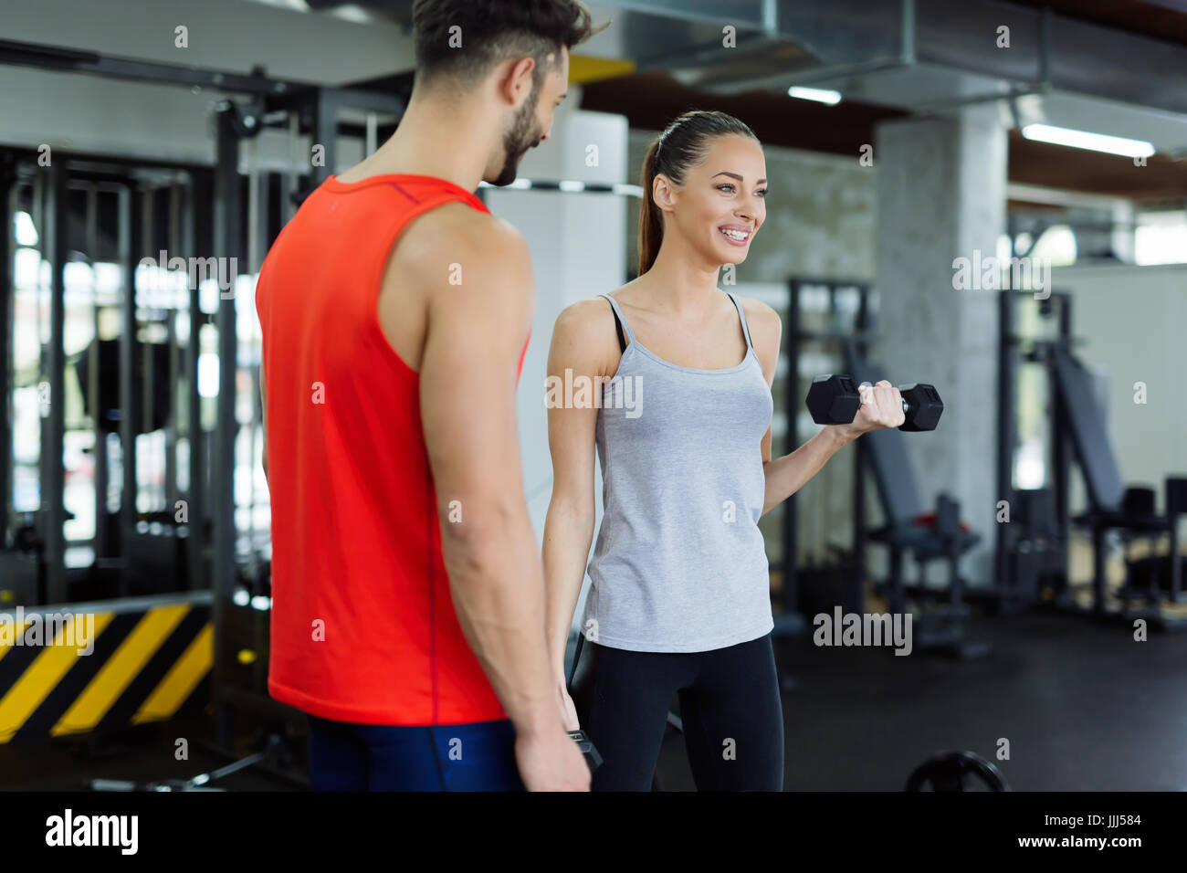Young adult woman working out in gym with trainer Stock Photo - Alamy