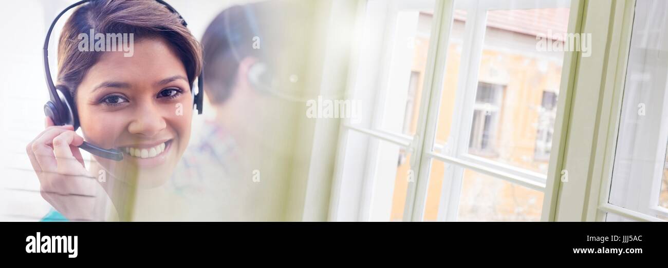 Customer service assistants with headsets with bright window background ...