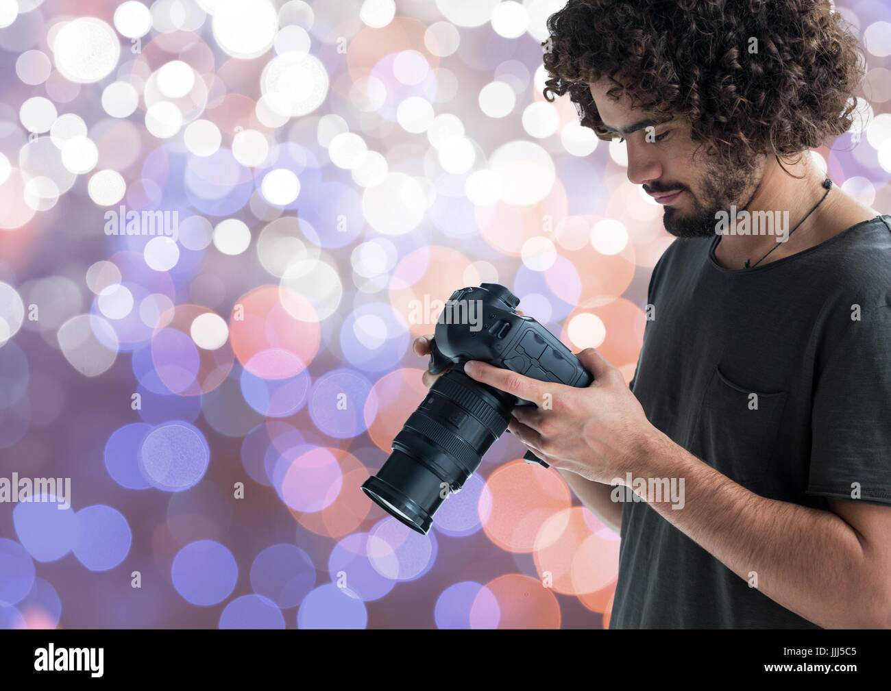 young photographer looking the photos on the camera. Blue, purple and ...