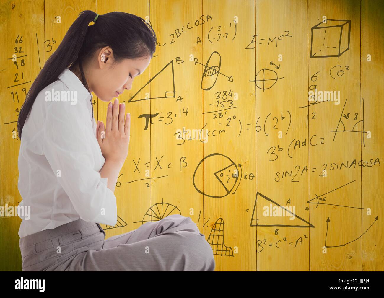 Business woman meditating against 3D yellow wood panel and math graphic ...
