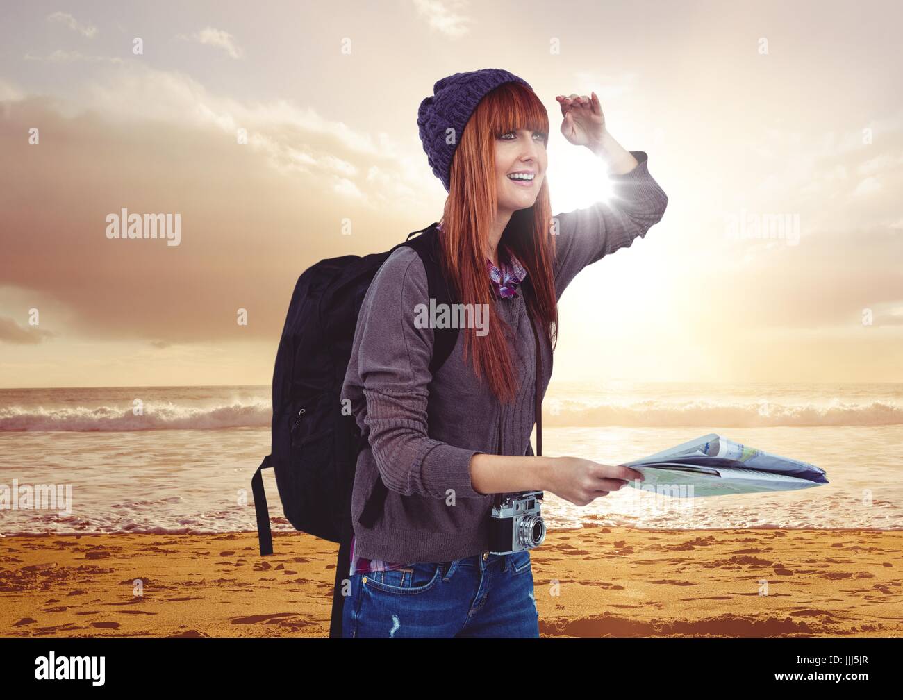 Millennial backpacker with map on sunset beach with flare Stock Photo ...