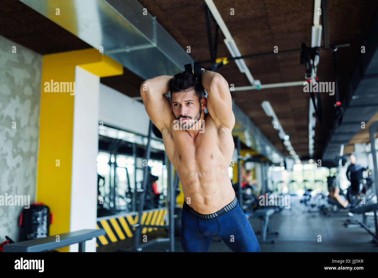 Young man doing trx exercise in gym Stock Photo - Alamy