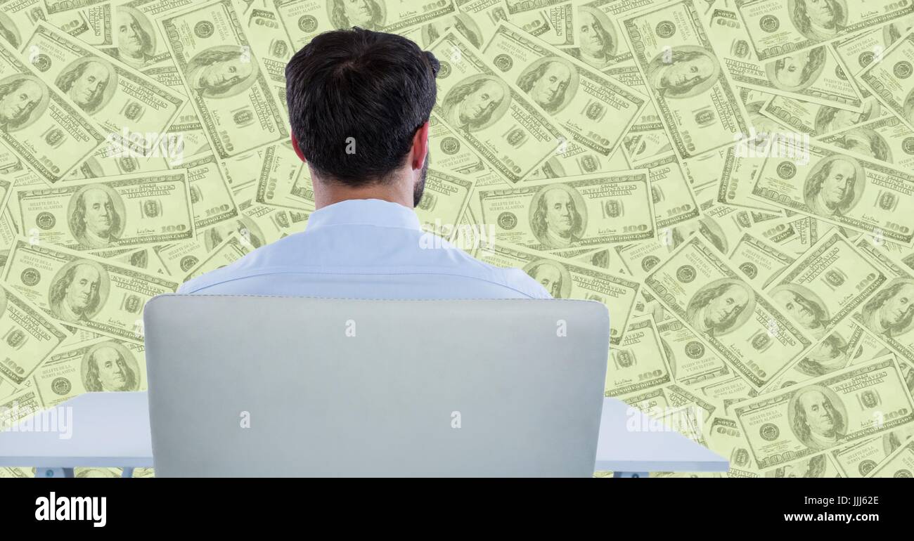 Back of business man at desk looking at green money backdrop Stock ...