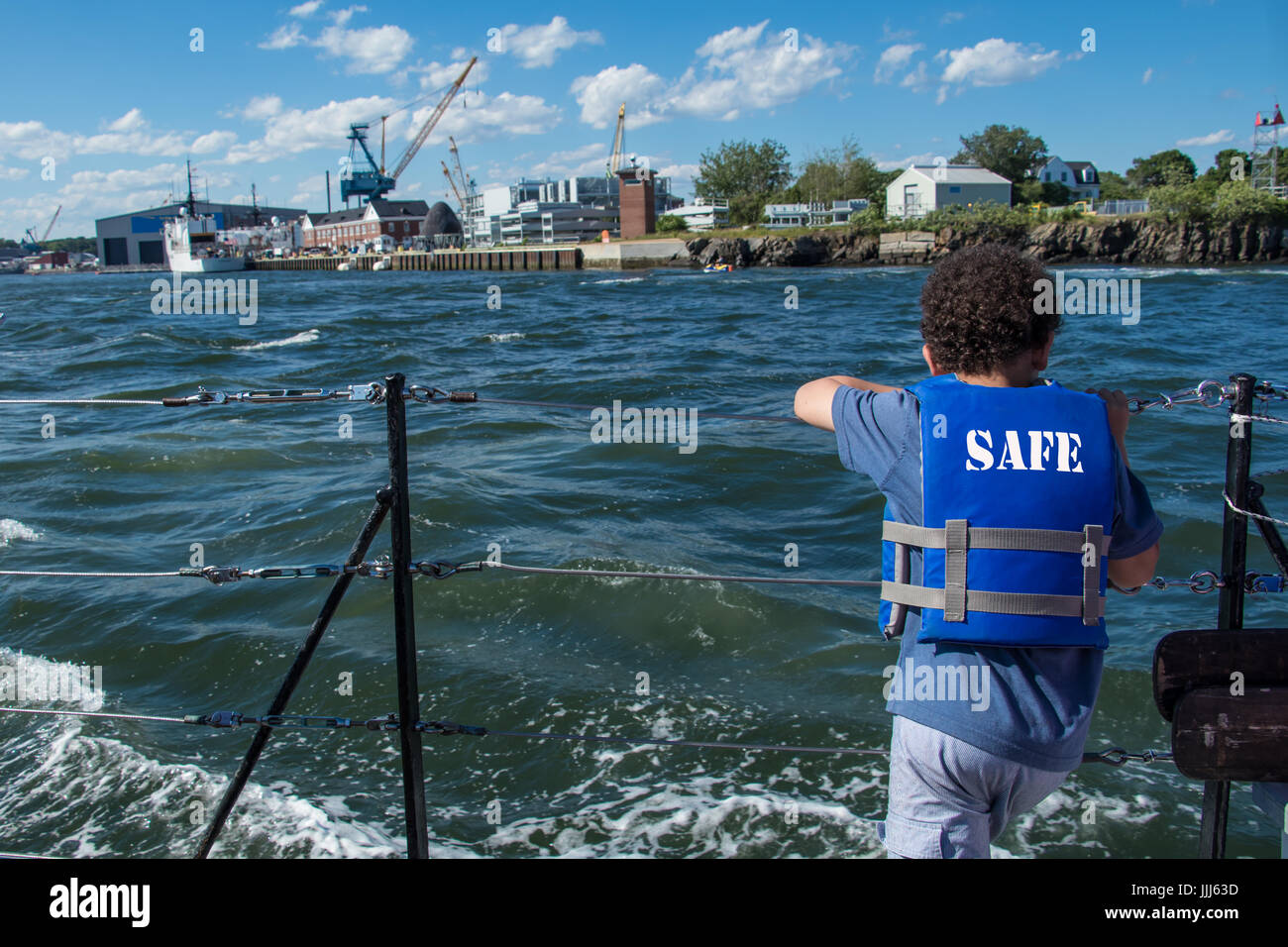 Child wearing blue life jacket standing in boat Stock Photo - Alamy