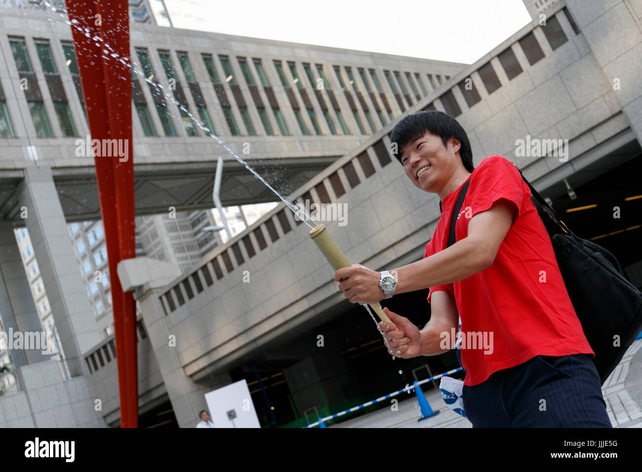 Tokyo, Japan. 20th July, 2017. A man enjoys sprinkling water during the ...