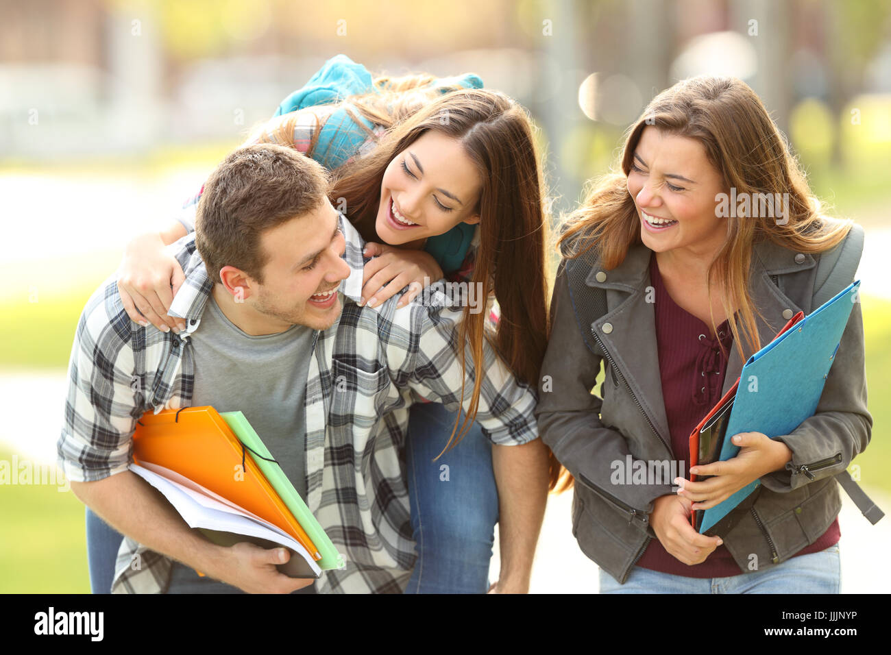 Three happy students and friends joking and laughing together in an ...