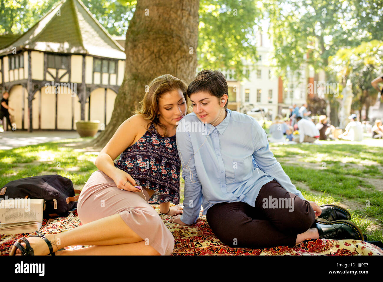 A young lesbian couple enjoy the sunshine in the park Stock Photo - Alamy