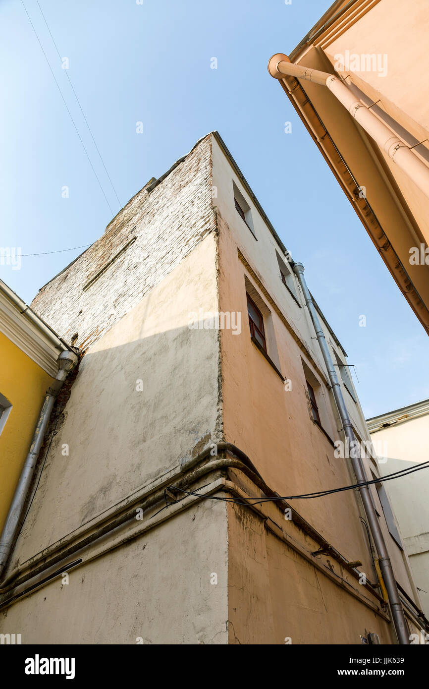 run-down apartment buildings on clear blue sky background. view up ...