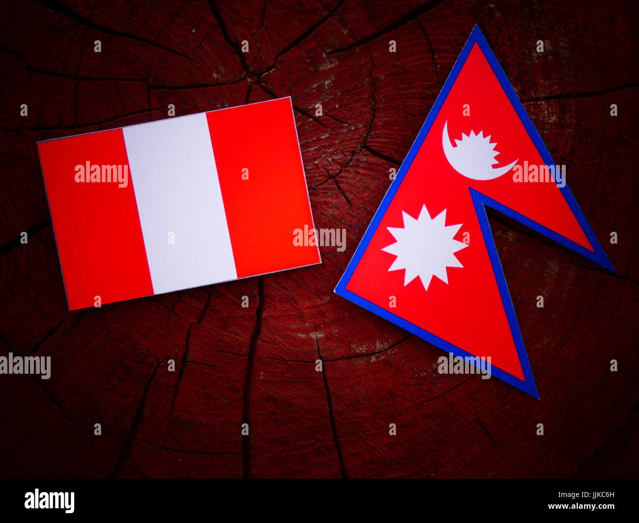 Peruvian flag with Nepali flag on a tree stump isolated Stock Photo - Alamy