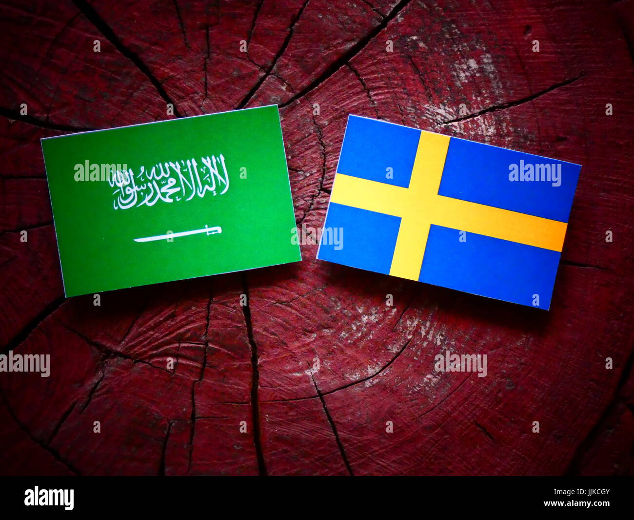 Saudi Arabian flag with Swedish flag on a tree stump isolated Stock ...
