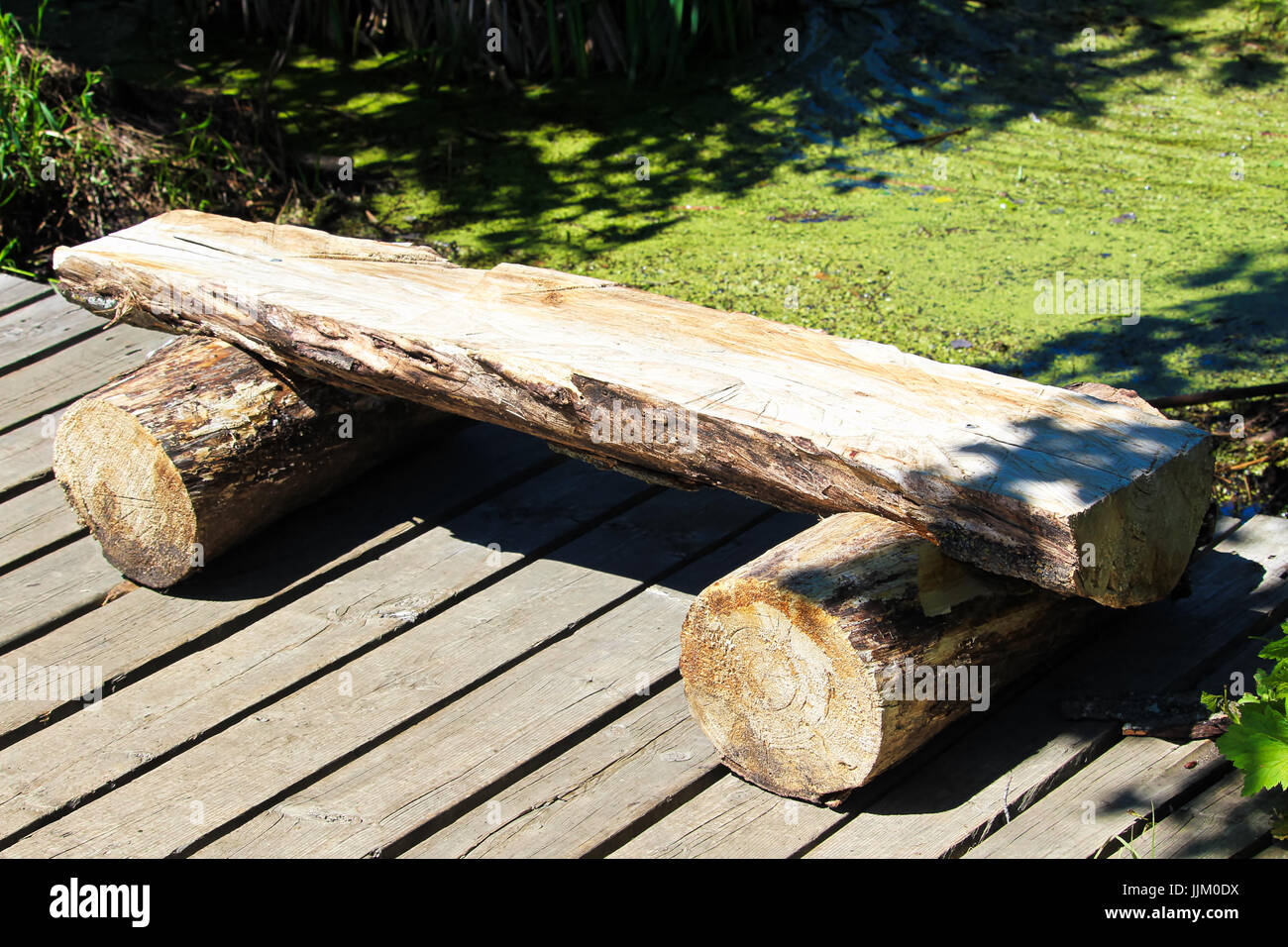 A split log wooden bench on a boardwalk trail Stock Photo - Alamy