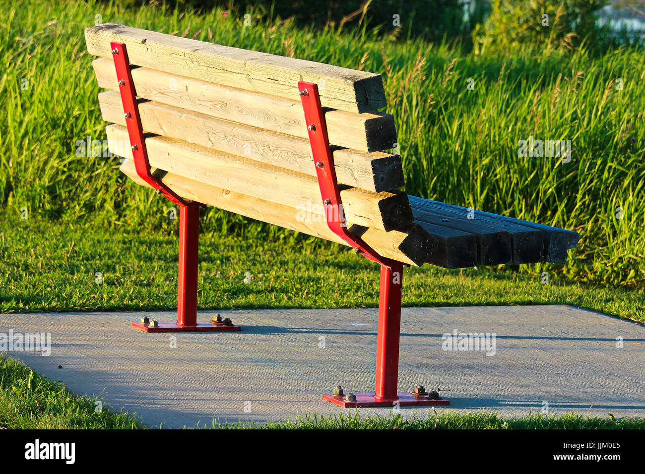 A park bench on a concrete base Stock Photo - Alamy