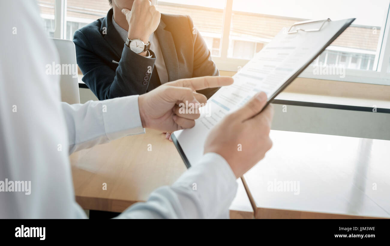 business man interviewer looking skeptical while listening to an asian ...