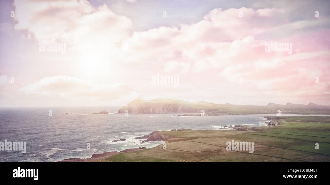 Idyllic view of landscape by ocean against sky Stock Photo - Alamy