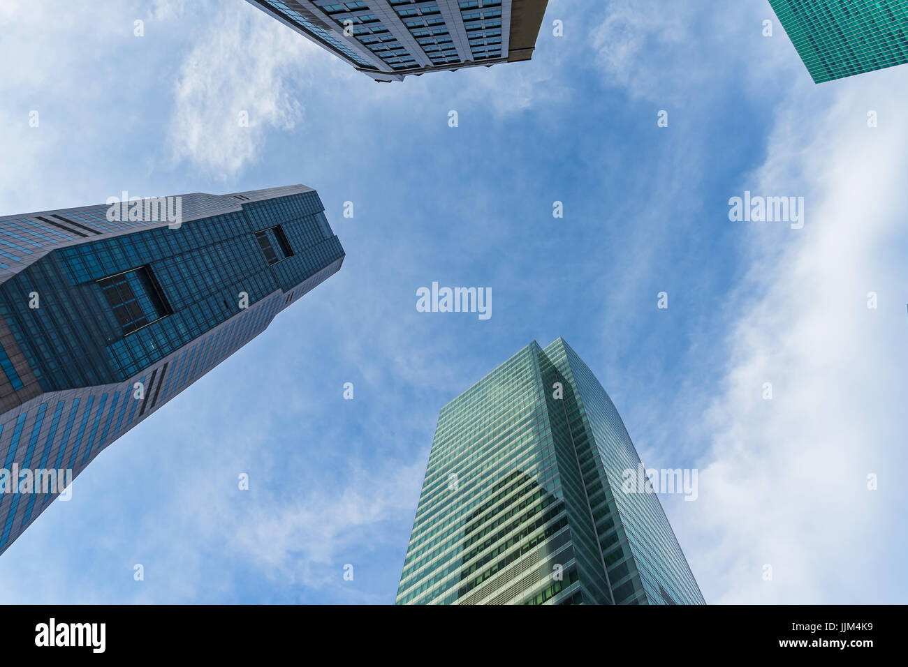 Bottom view of modern skyscrapers in business district against blue sky ...