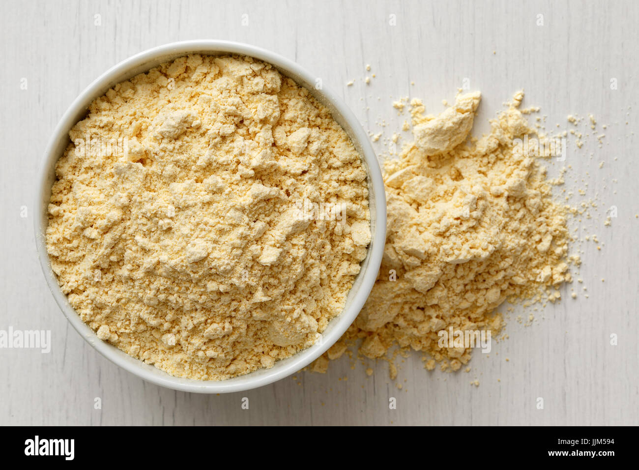 Chickpea flour in white ceramic bowl isolated on painted white wood ...