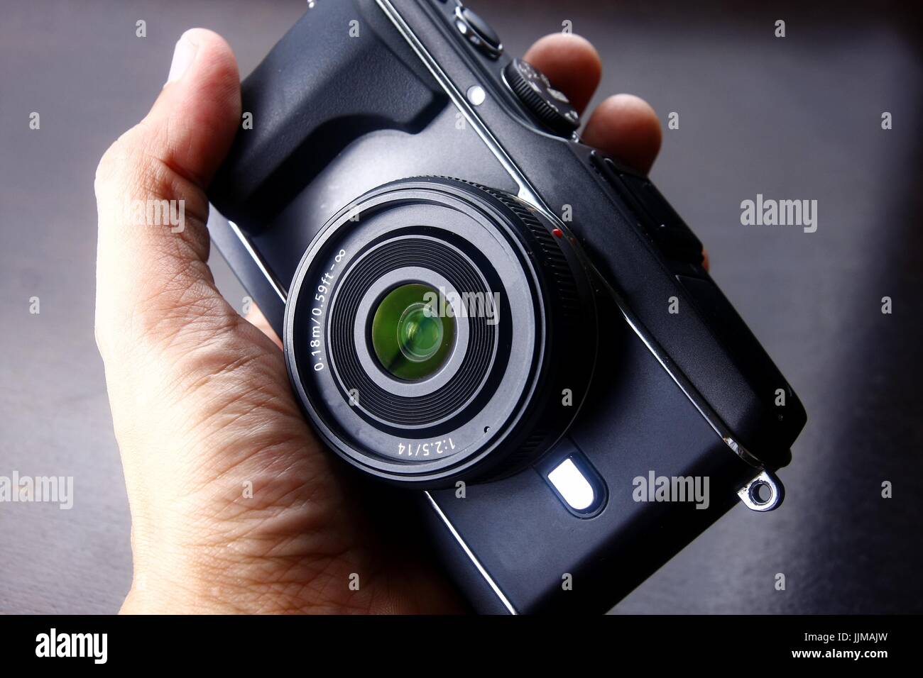 Photo of a hand holding a digital mirrorless camera Stock Photo - Alamy
