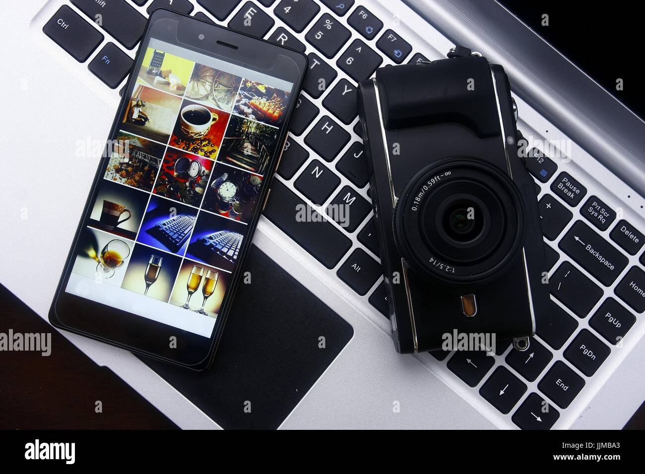 Photo of a smartphone,digital mirrorless camera and laptop computer ...