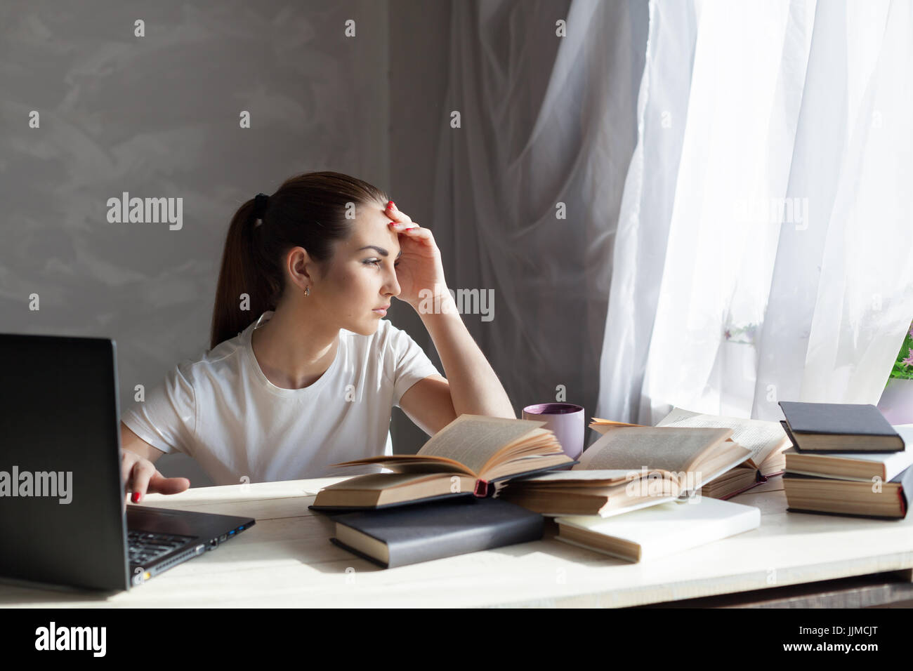 girl works at the computer reads books Stock Photo - Alamy