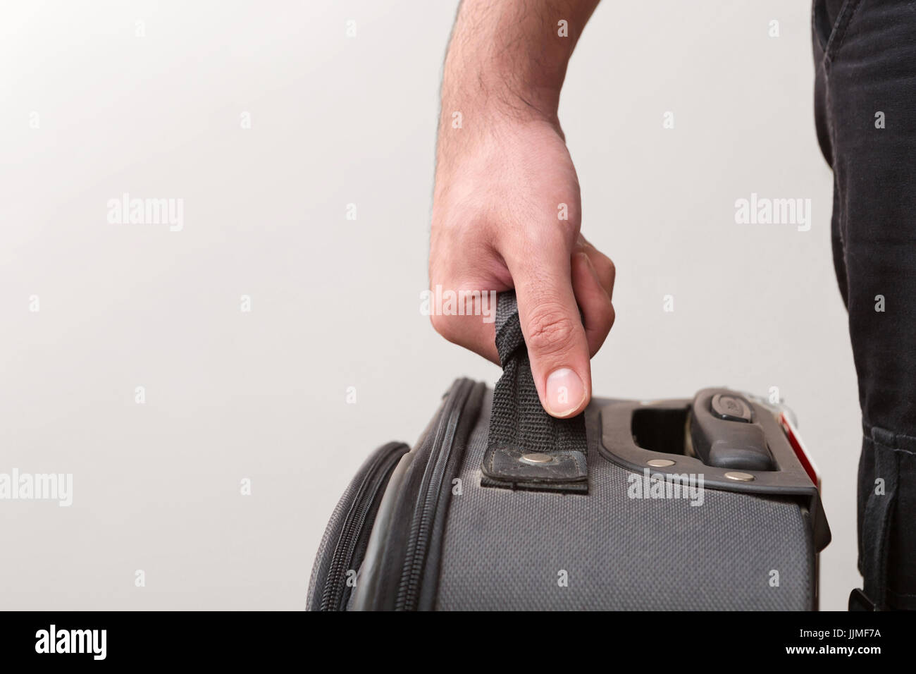 Man Holding One Carry on Suitcase on a Simple Plane Background Stock ...