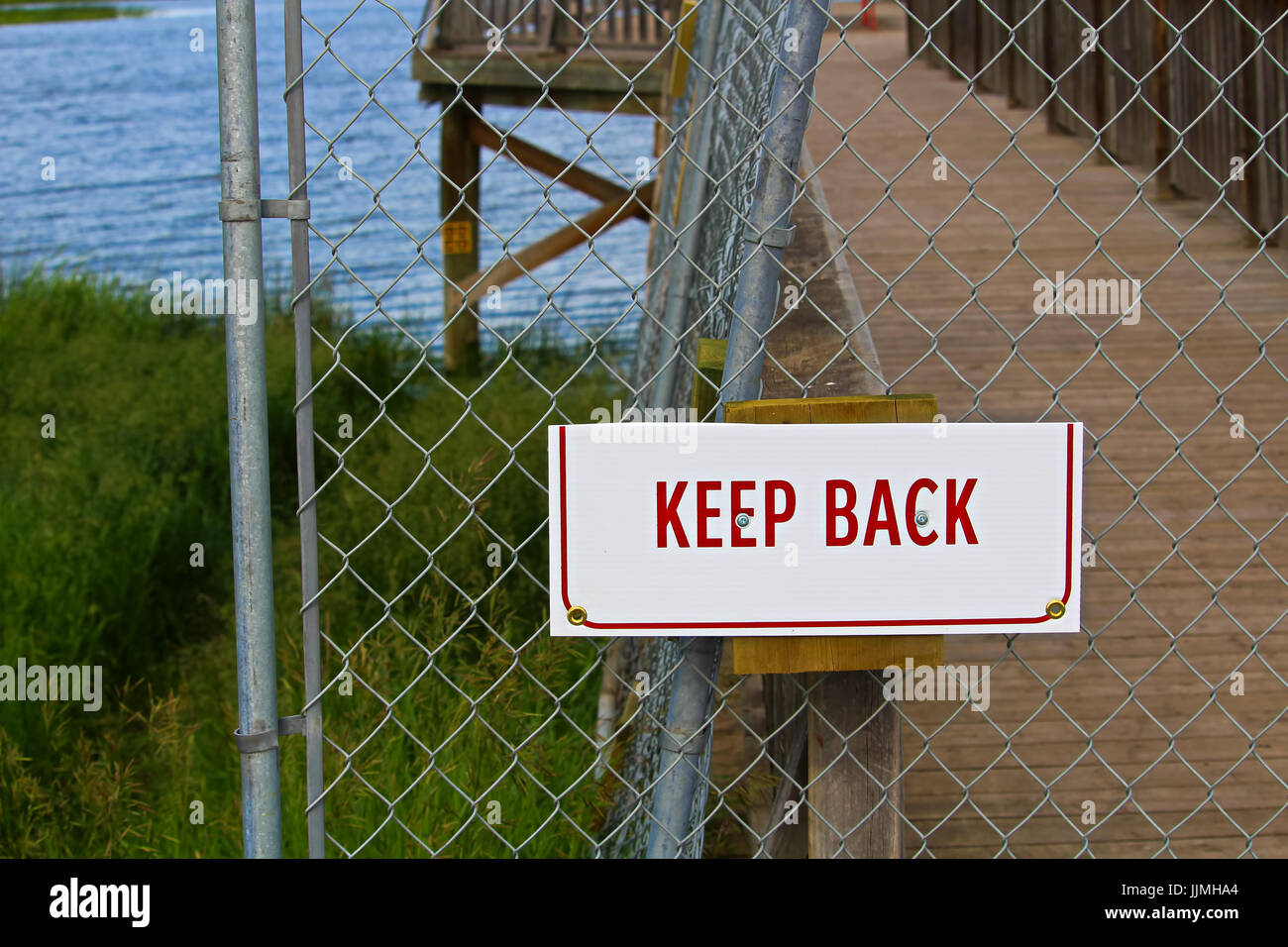A keep back sign on a chain-link fence Stock Photo - Alamy