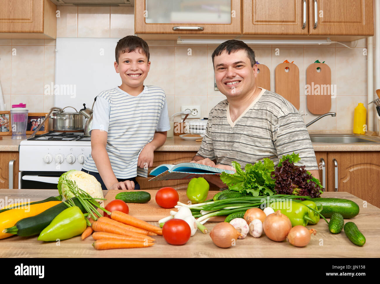 Father and child reading cooking book and choice dishes. Happy family ...