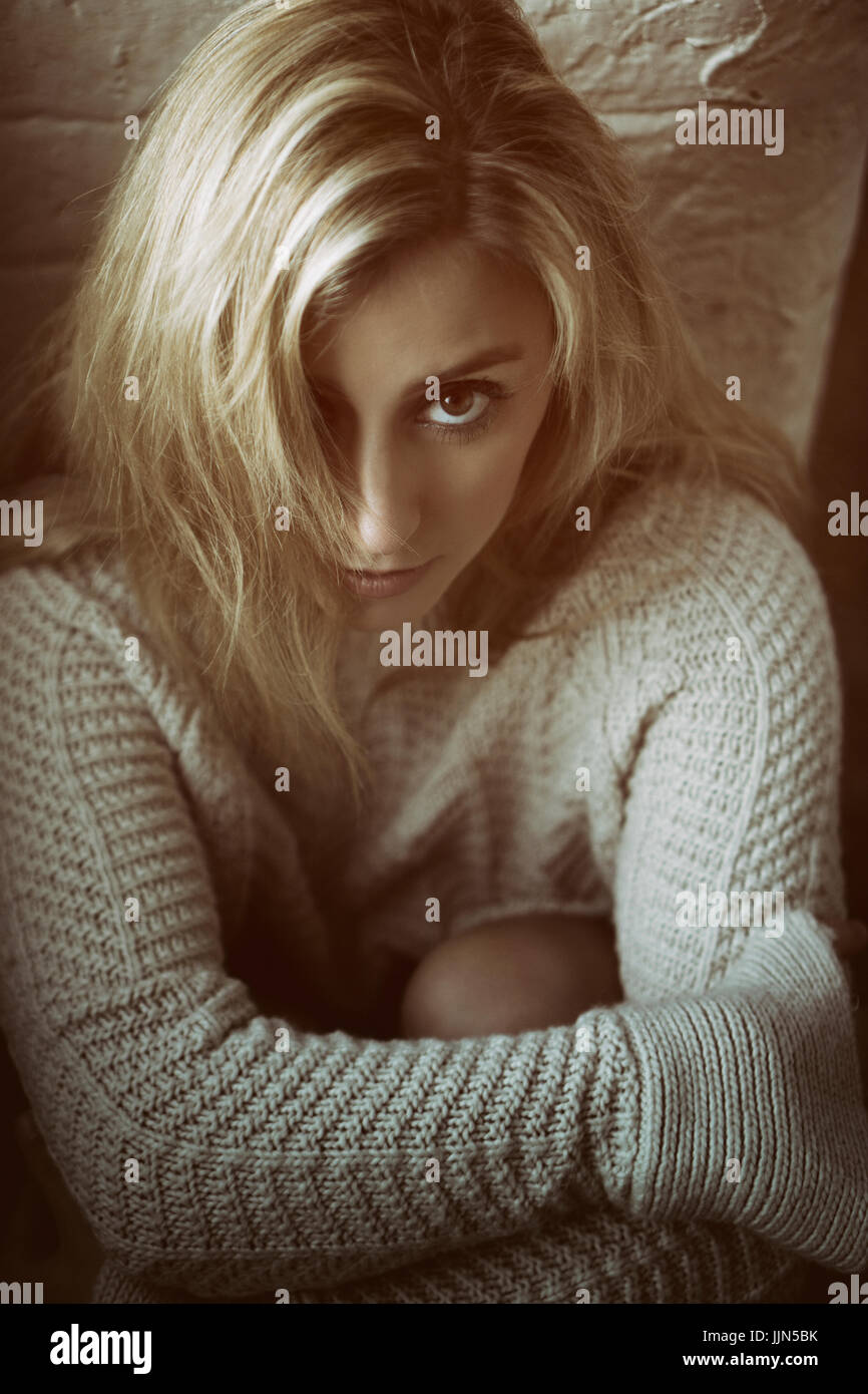 Scared young woman sitting down staring Stock Photo - Alamy