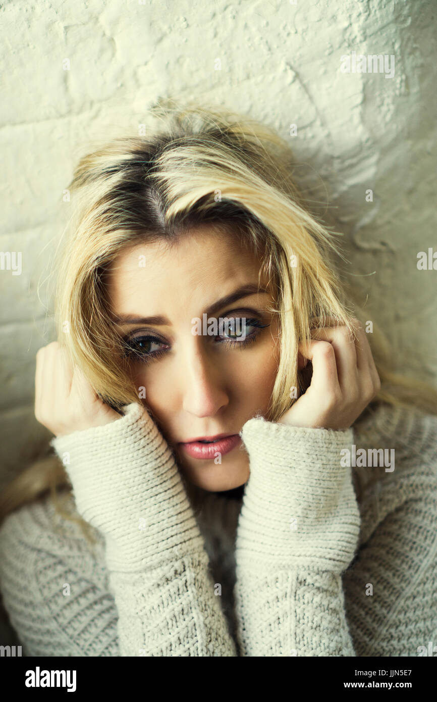 Scared young woman head in hands looking away Stock Photo - Alamy