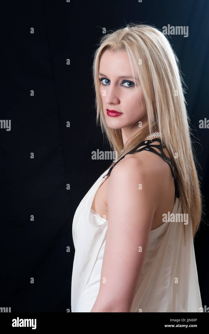 Serious blond woman looking over shoulder Stock Photo - Alamy