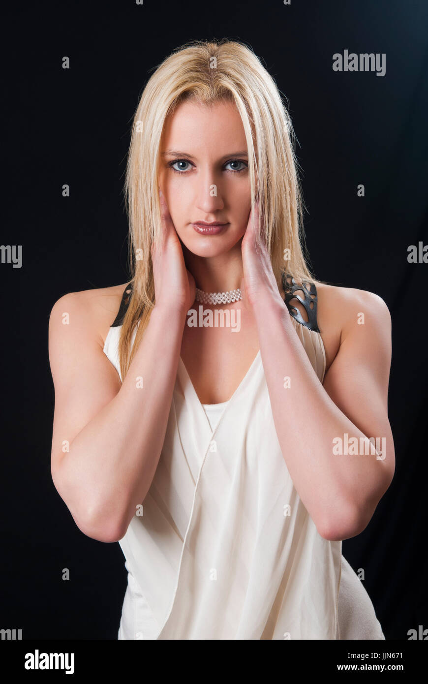 Beautiful blond woman hands touching neck staring Stock Photo - Alamy