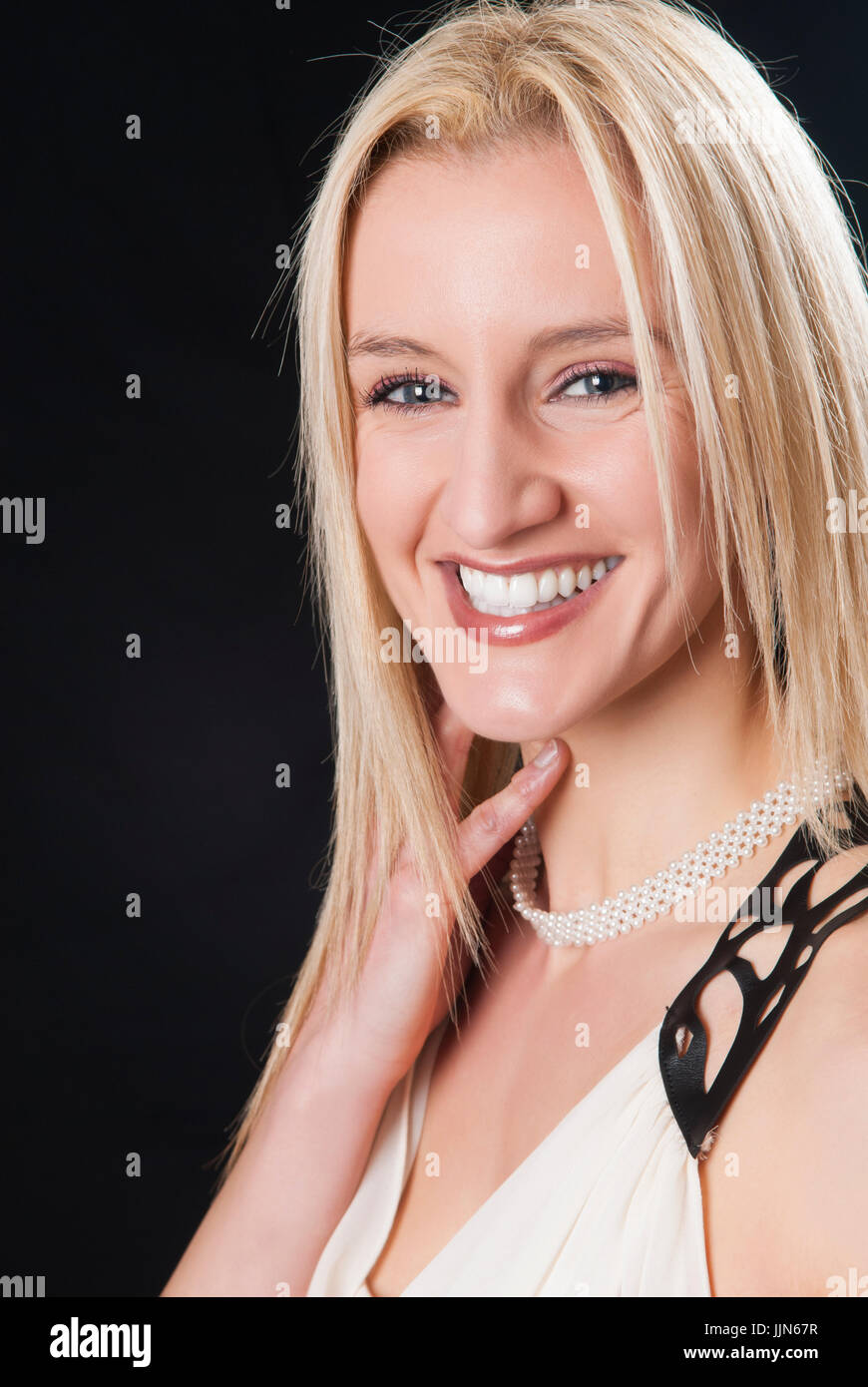 Happy blond woman hand touching neck smiling Stock Photo - Alamy