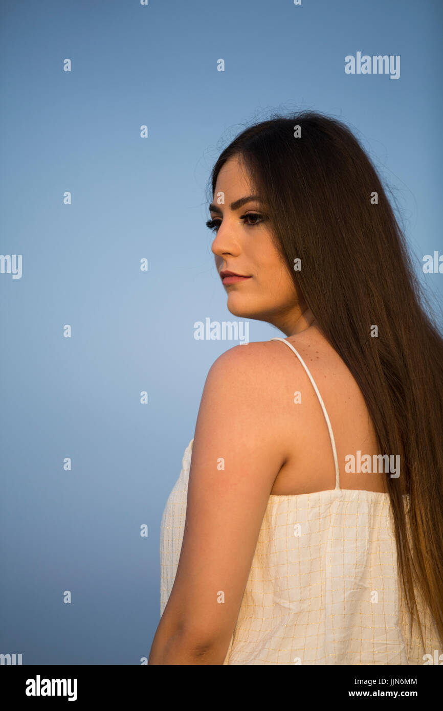 Beautiful yuoung woman looking over shoulder Stock Photo - Alamy