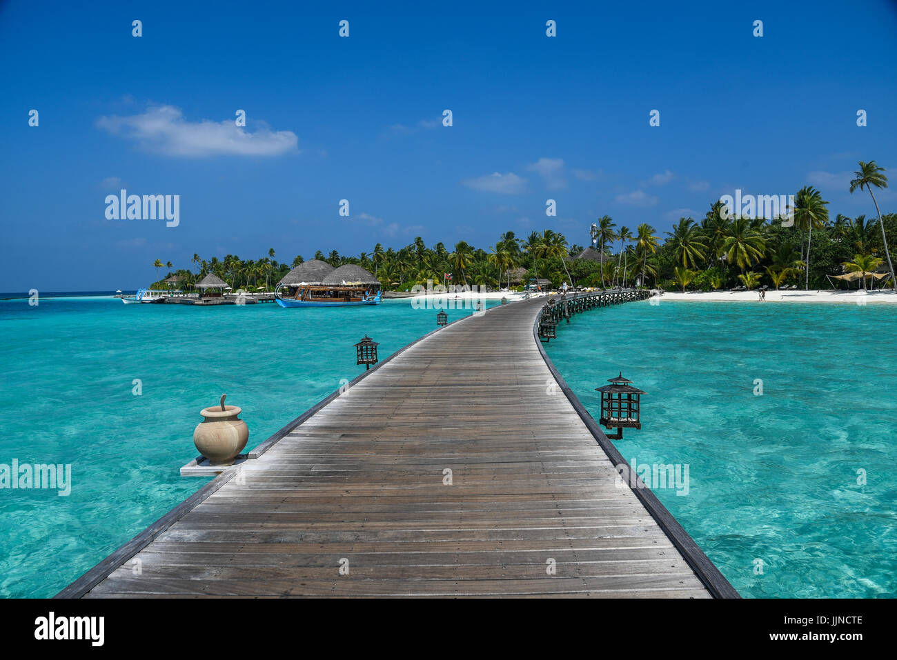 The jetty of a luxury resort leading from the over-water villas to the ...