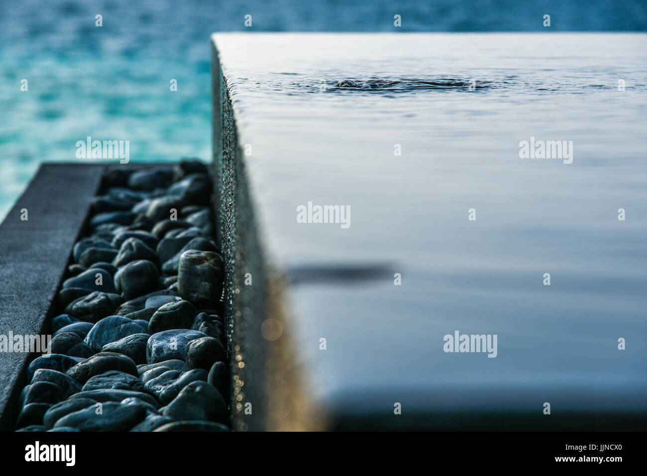 An infinity pool bubbling peacefully as it overflows into an attractive ...
