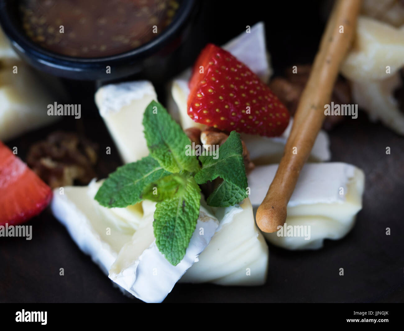 Italian chesse plate on black dish Stock Photo - Alamy