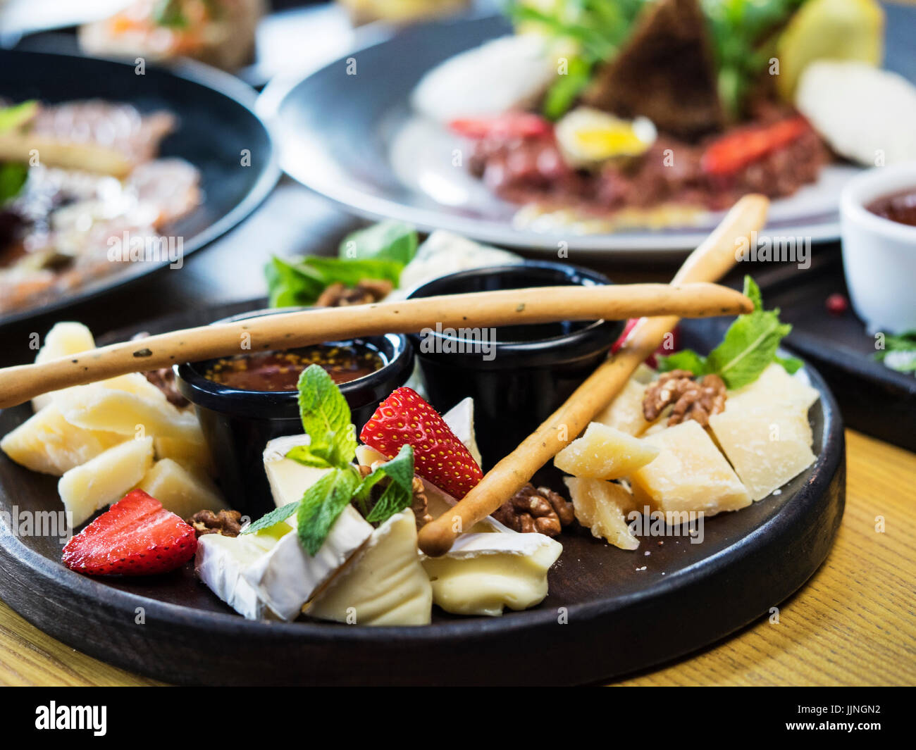 Italian chesse plate on black dish Stock Photo - Alamy